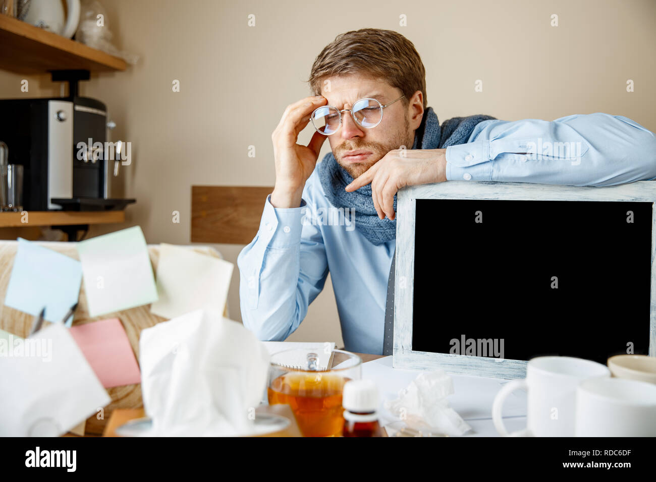 Sick man with empty poster for copyspace while working in office ...