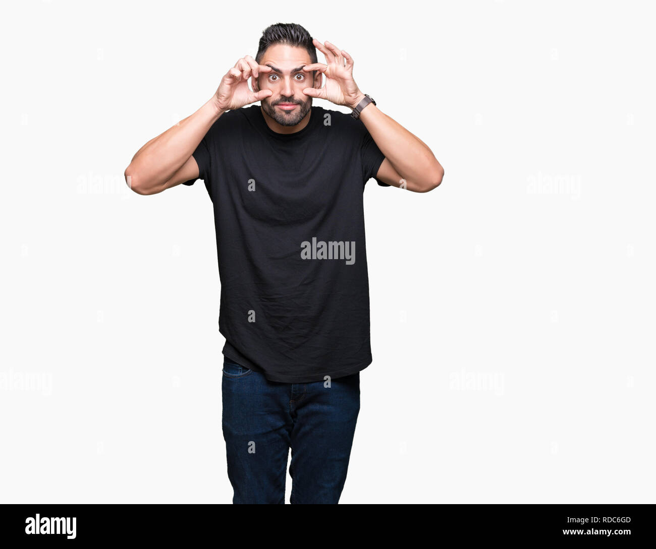 Young handsome man over isolated background Trying to open eyes with ...