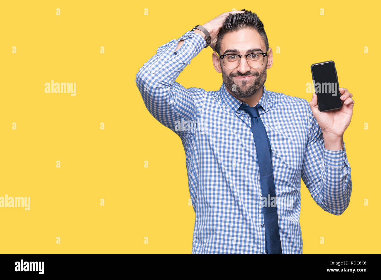 Young business man showing smartphone screen over isolated background ...