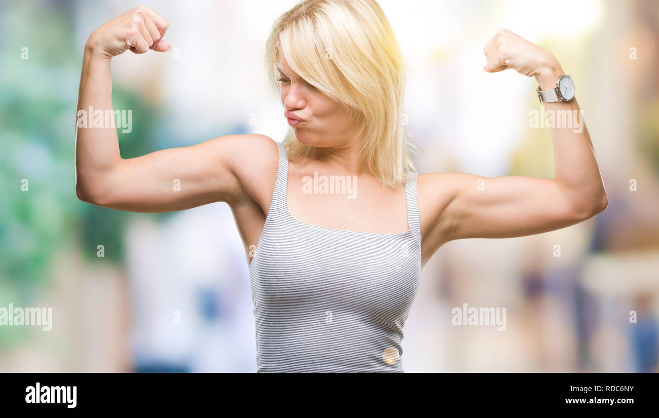 Young beautiful blonde woman over isolated background showing arms ...