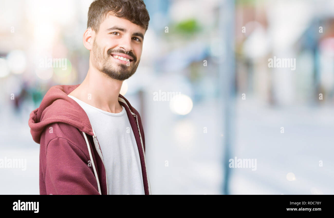 Young handsome man over isolated background Inviting to enter smiling ...