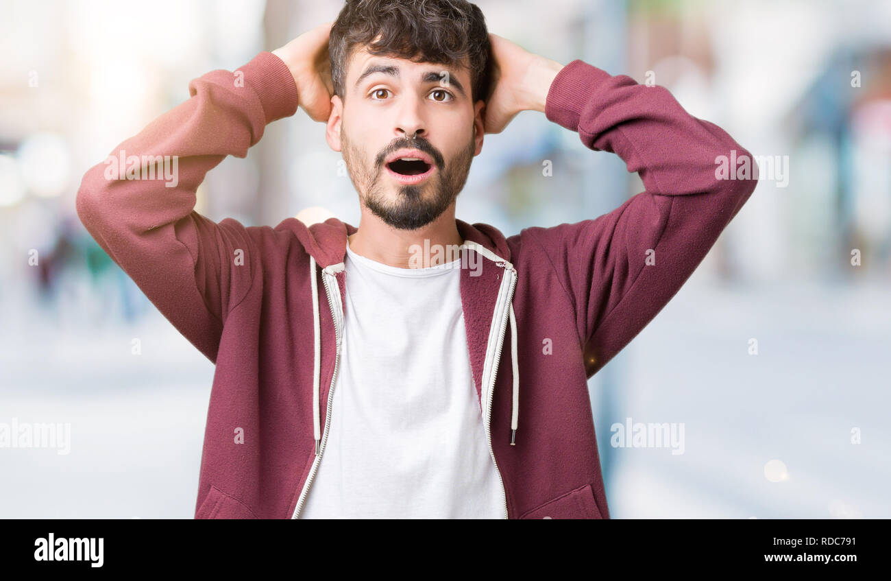 Young handsome man over isolated background Crazy and scared with hands ...