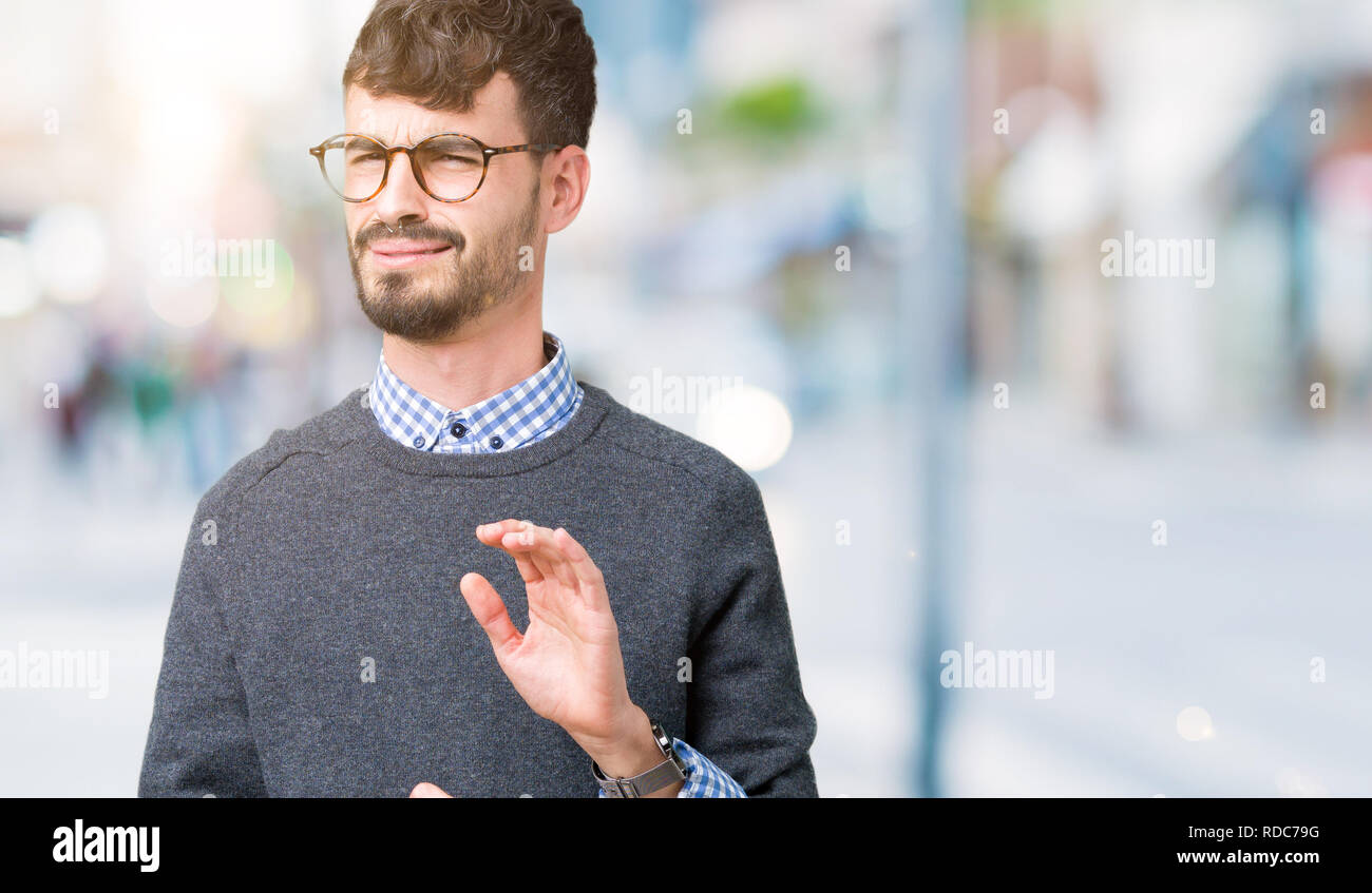 Young handsome smart man wearing glasses over isolated background ...