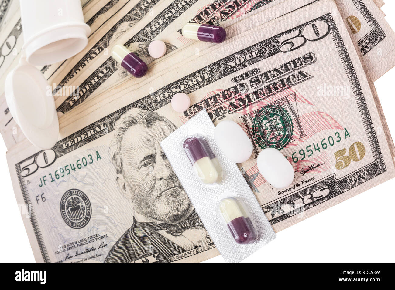 Pile of pills on American dollars isolated on white Stock Photo - Alamy