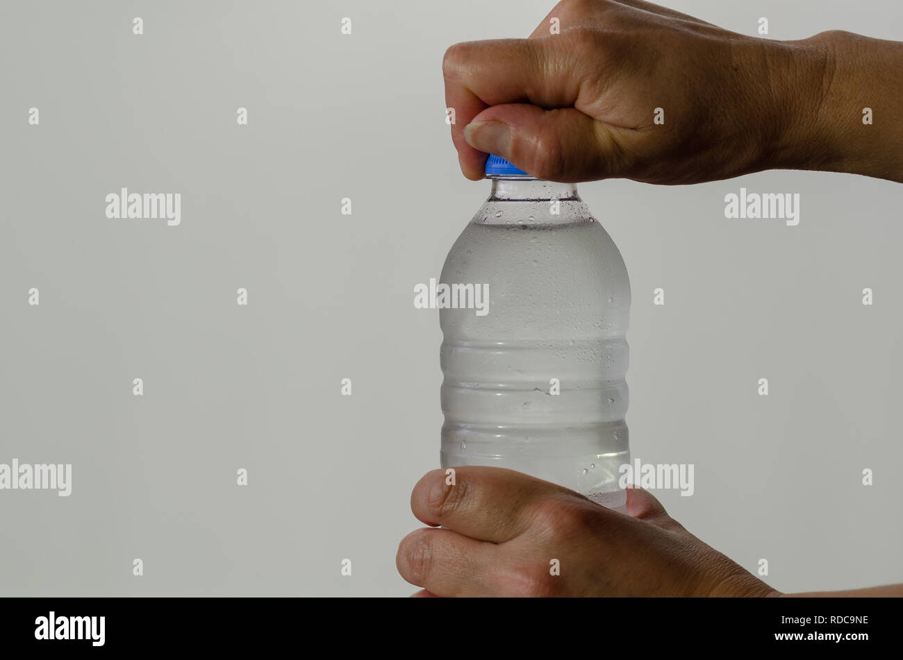 Woman is trying to open the cover of water bottle Stock Photo - Alamy