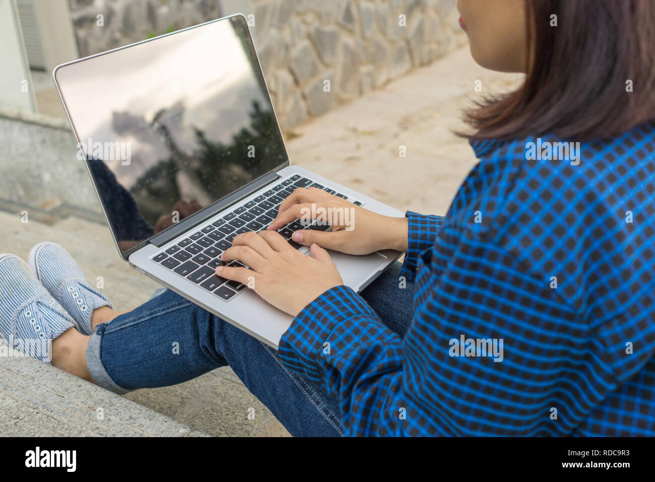 Female hands typing laptop on thigh Stock Photo - Alamy