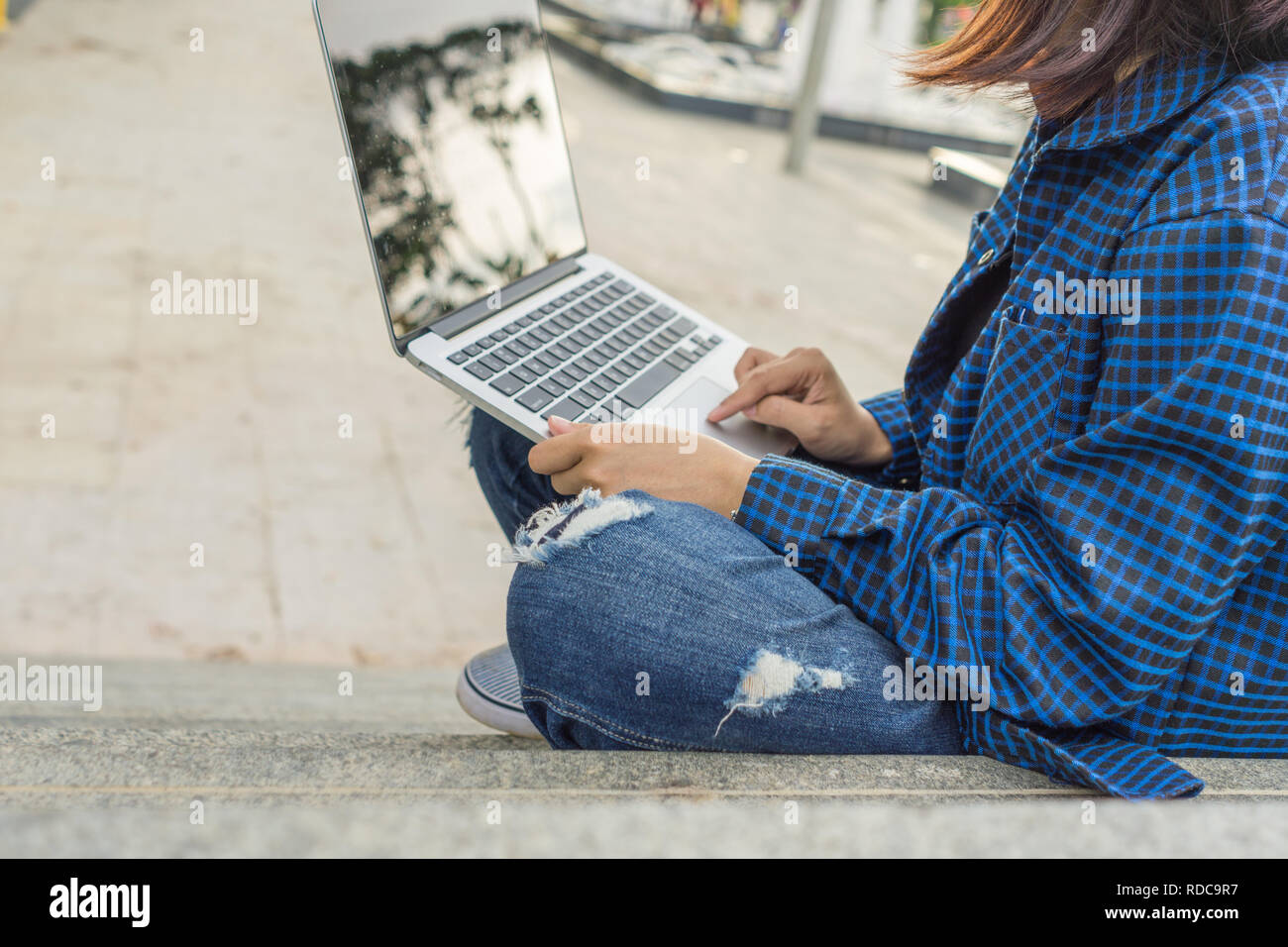 Student girl sitting in campus, doing assignment on laptop Stock Photo ...