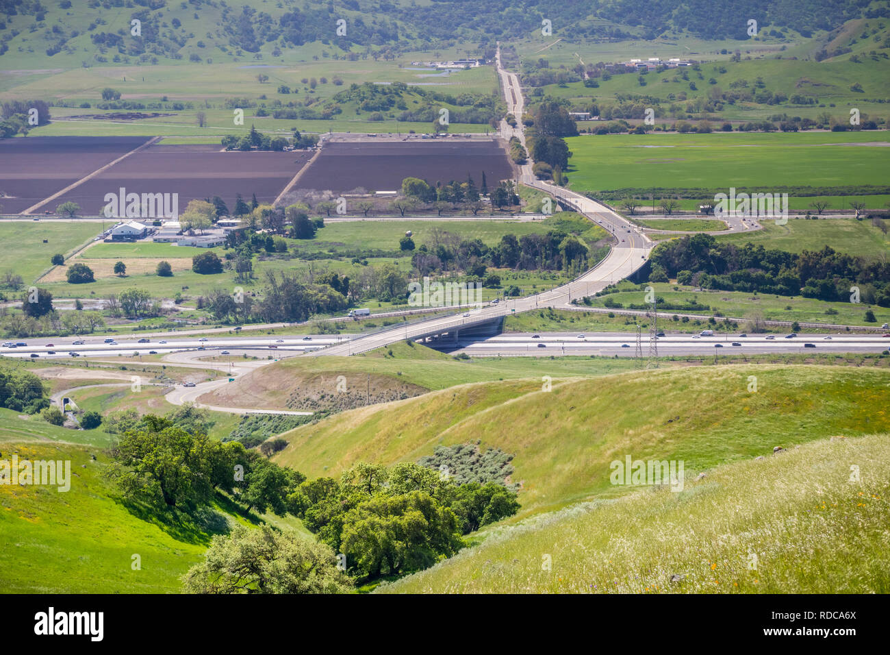 Aerial view of freeway junction and agricultural fields, mountain ...