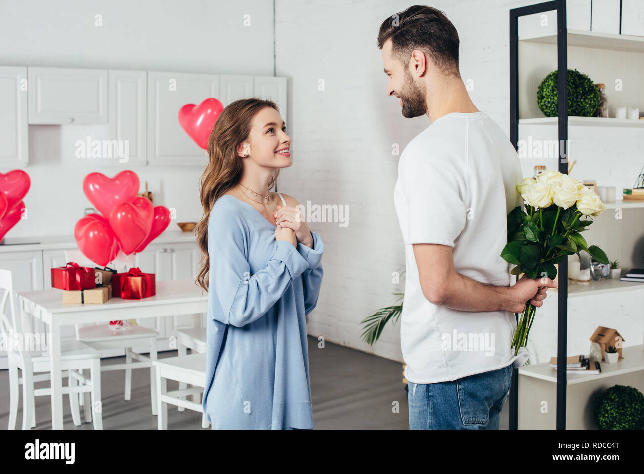 young smiling girl in joyful expectation of st valentines day gift ...