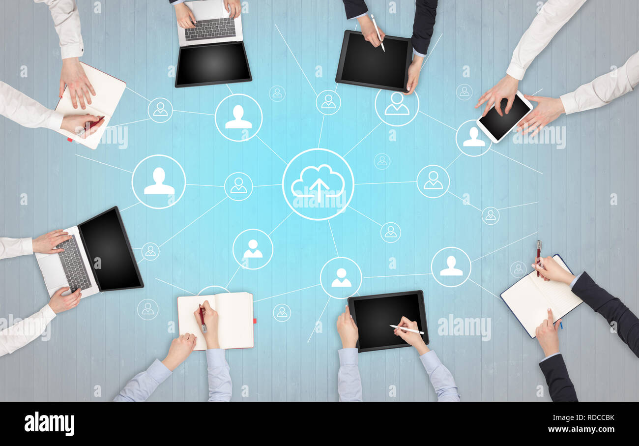 Group of people with devices in hands working in team on tablets ...