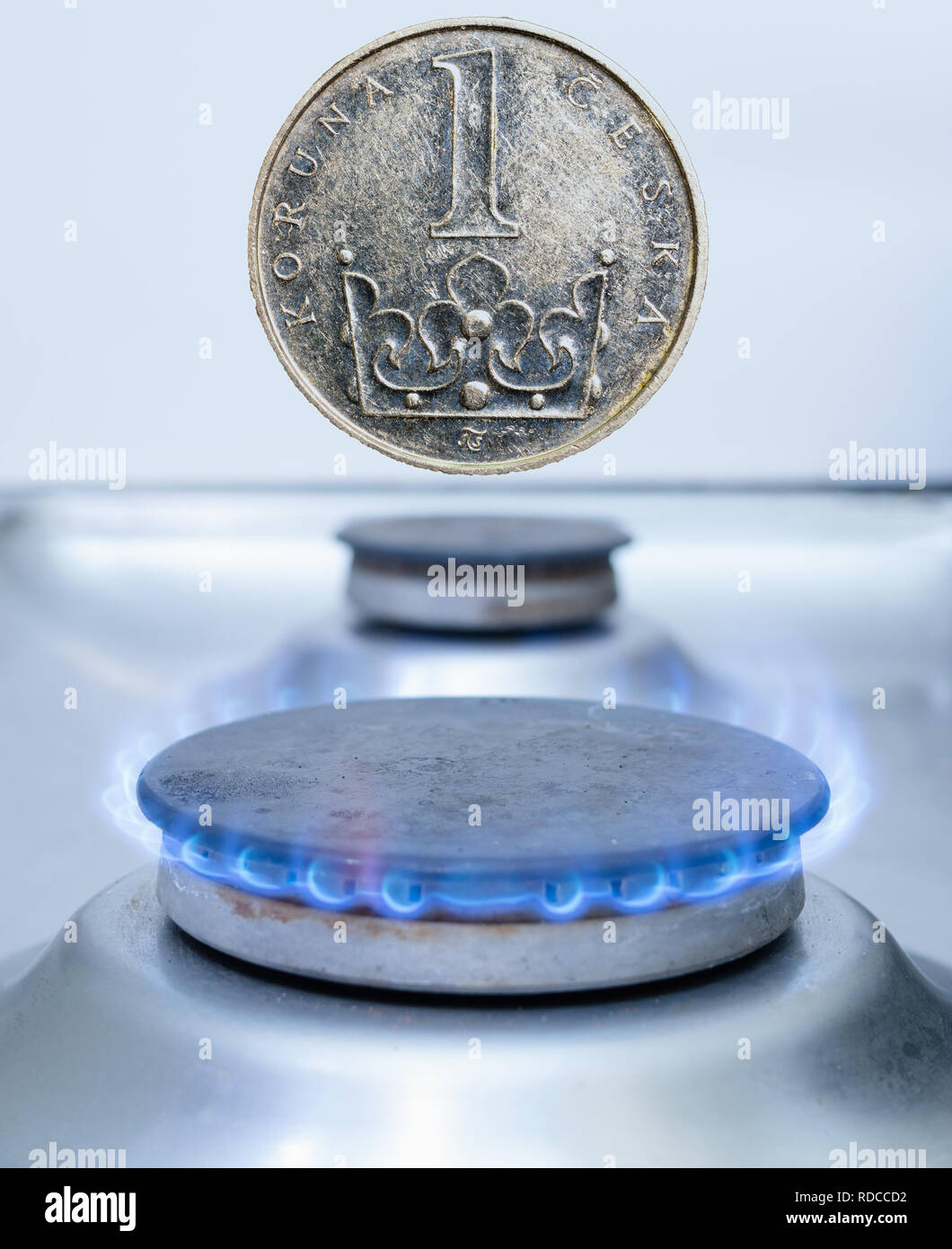 one Czech Republic coin koruna over gas burner. utility costs in Europe ...