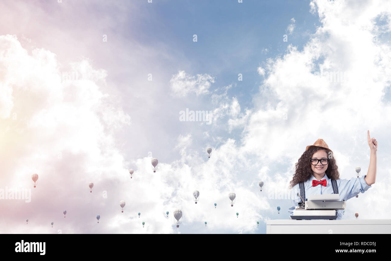 Young and beautiful woman writer in hat and eyeglasses using typing ...