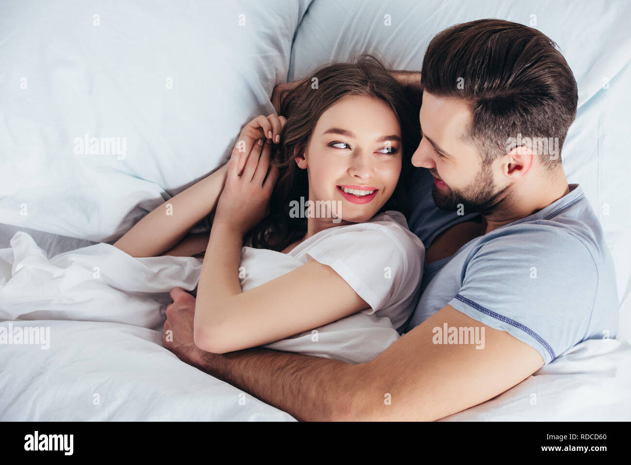 young loving couple gentle hugging in bed and looking into eyes Stock ...