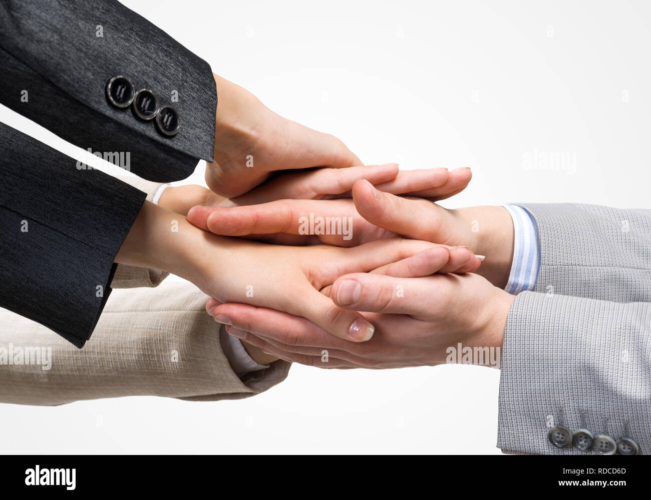 Close up of businesspeople putting their hands together against white ...
