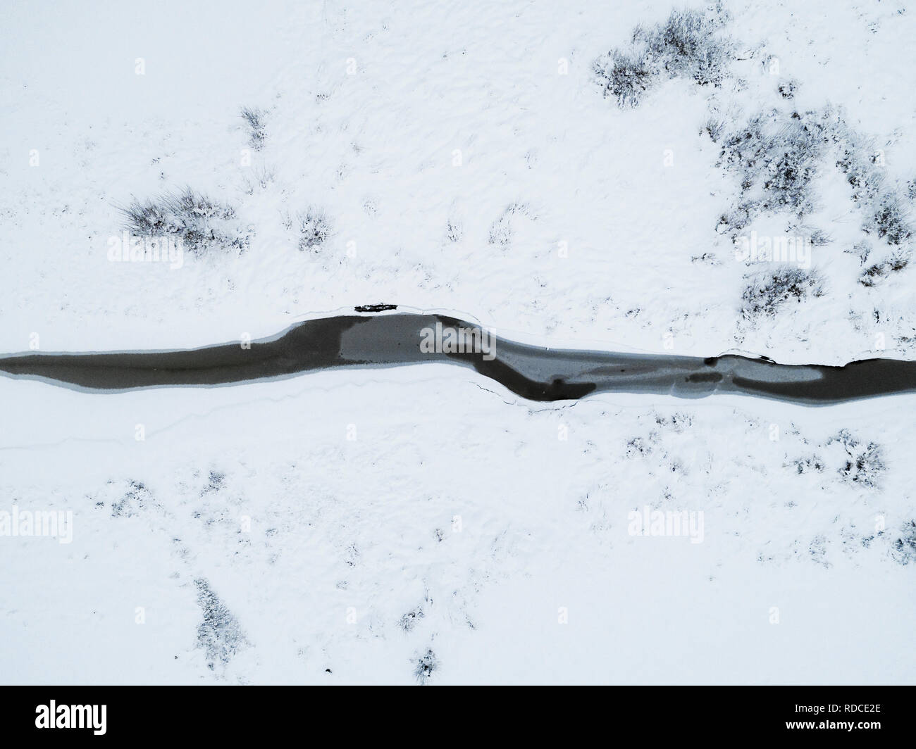 Aerial top view of frozen river among snow. Aerial winter landscape ...