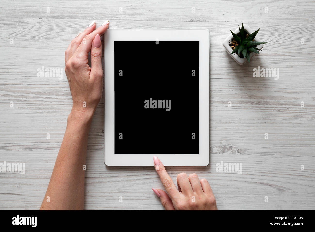 Female hands using tablet over white wooden background, overhead view ...