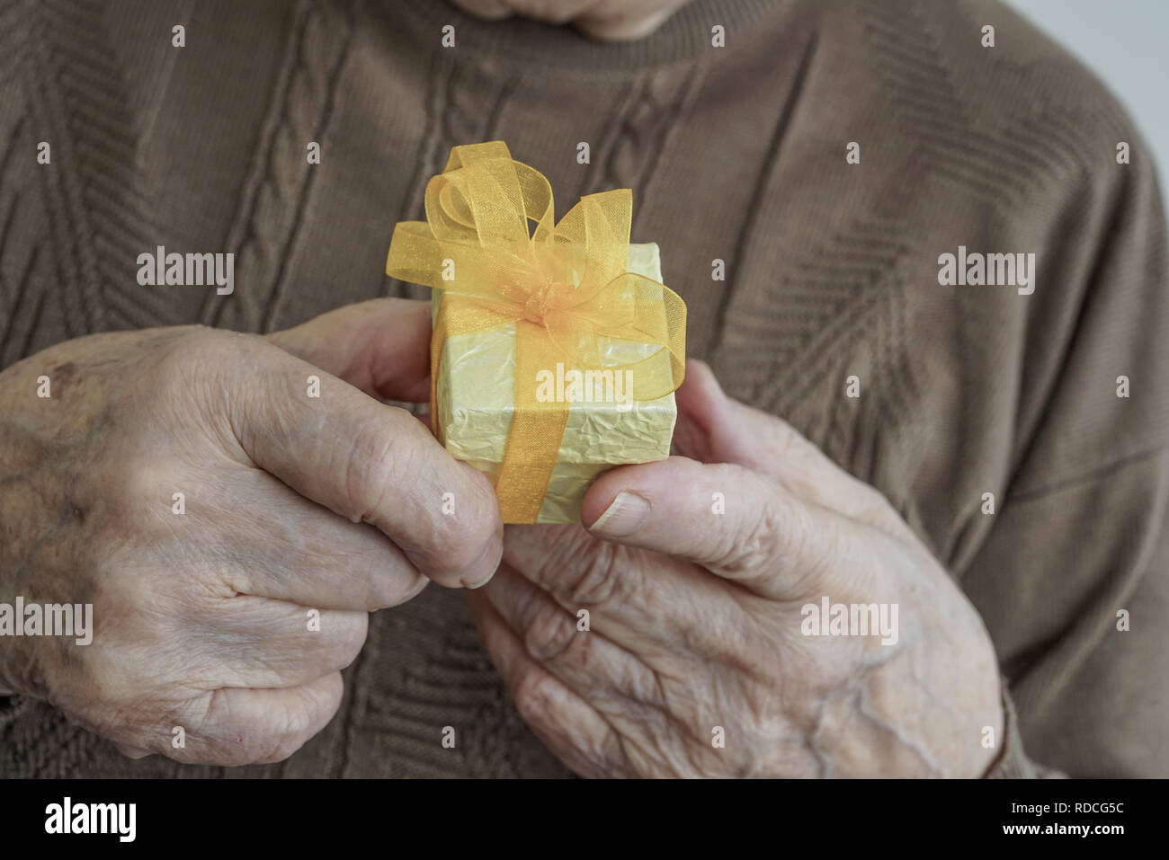 closeup wrinkled hands of a senior woman holding gift Stock Photo - Alamy