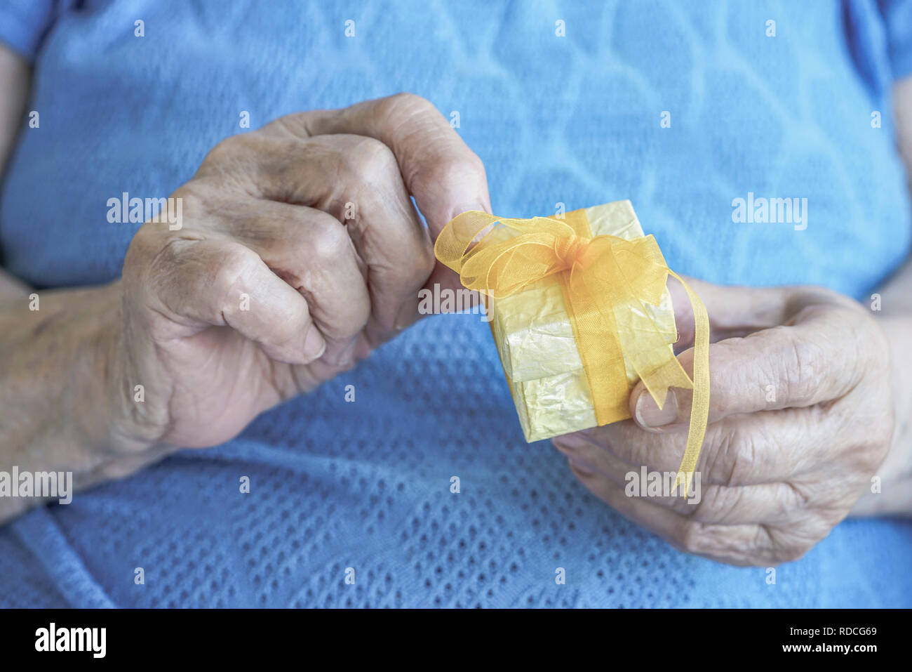 Closeup wrinkled hands of a senior person holding a gift box Stock ...