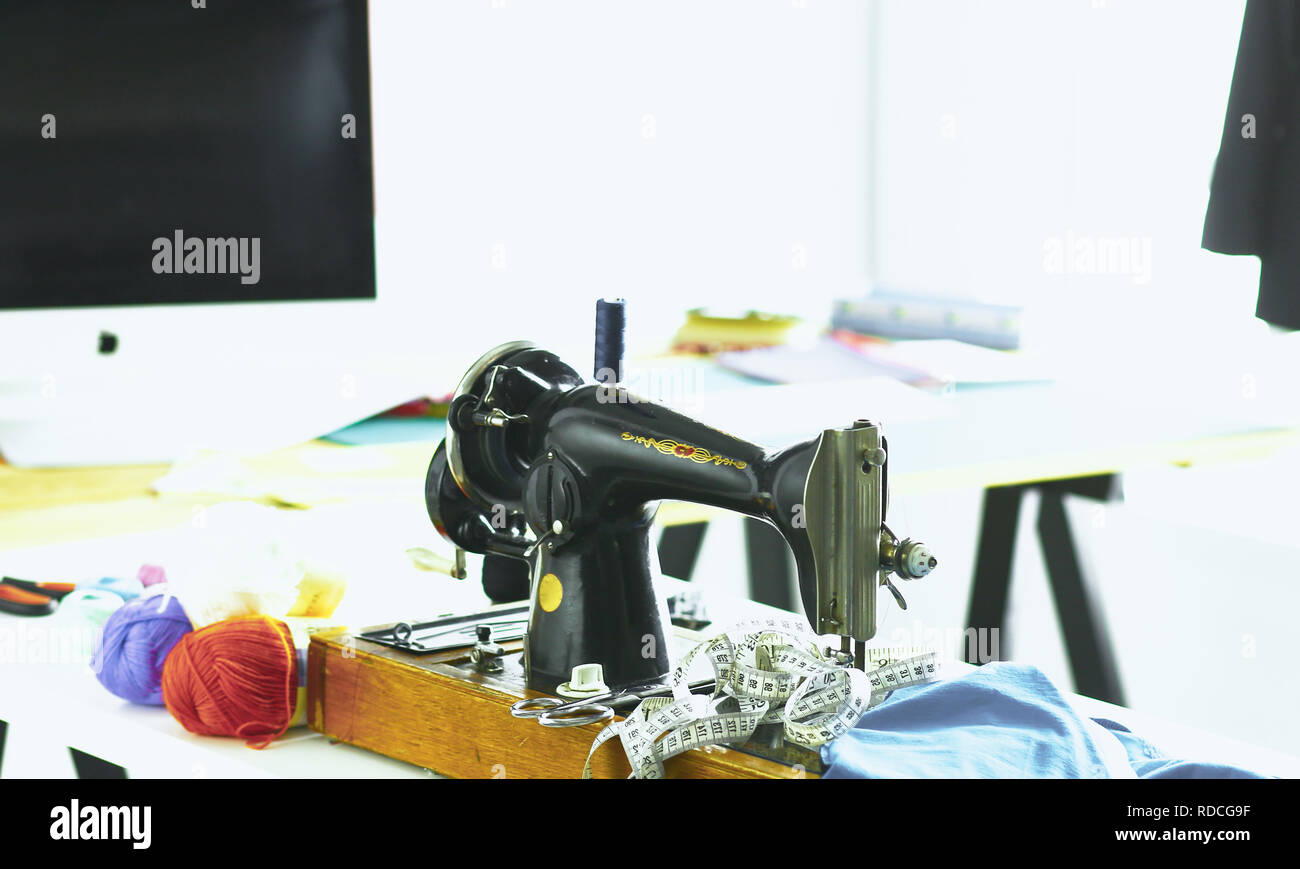 Retro sewing machine on designer clothes desktop Stock Photo - Alamy