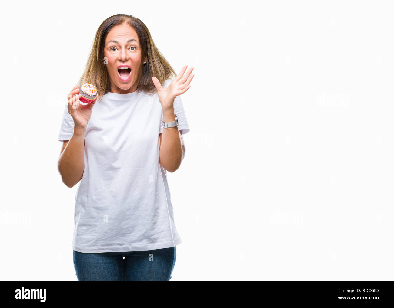 Middle age hispanic woman eating cupcake over isolated background very ...