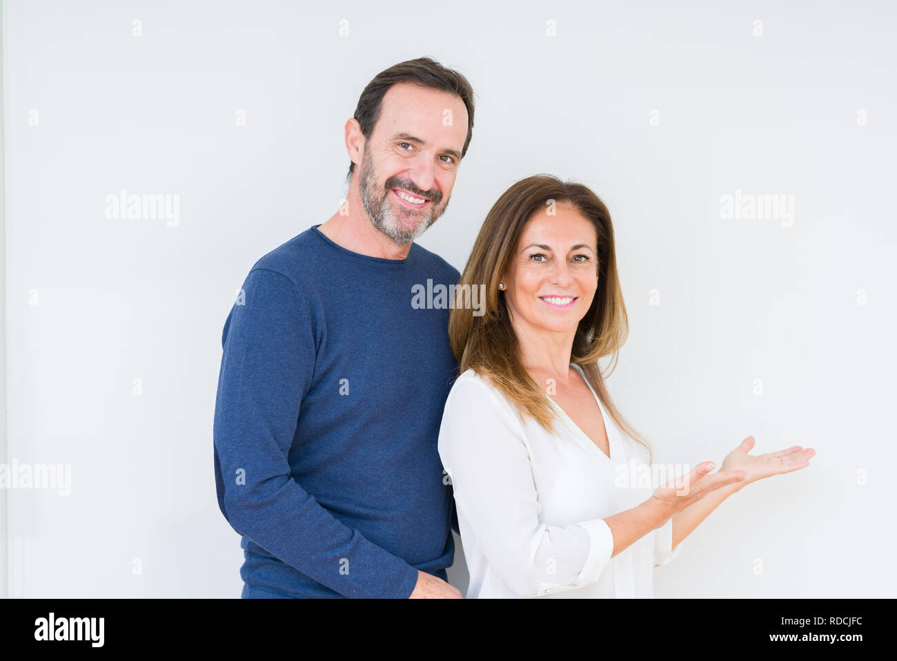 Beautiful middle age couple in love over isolated background Inviting ...