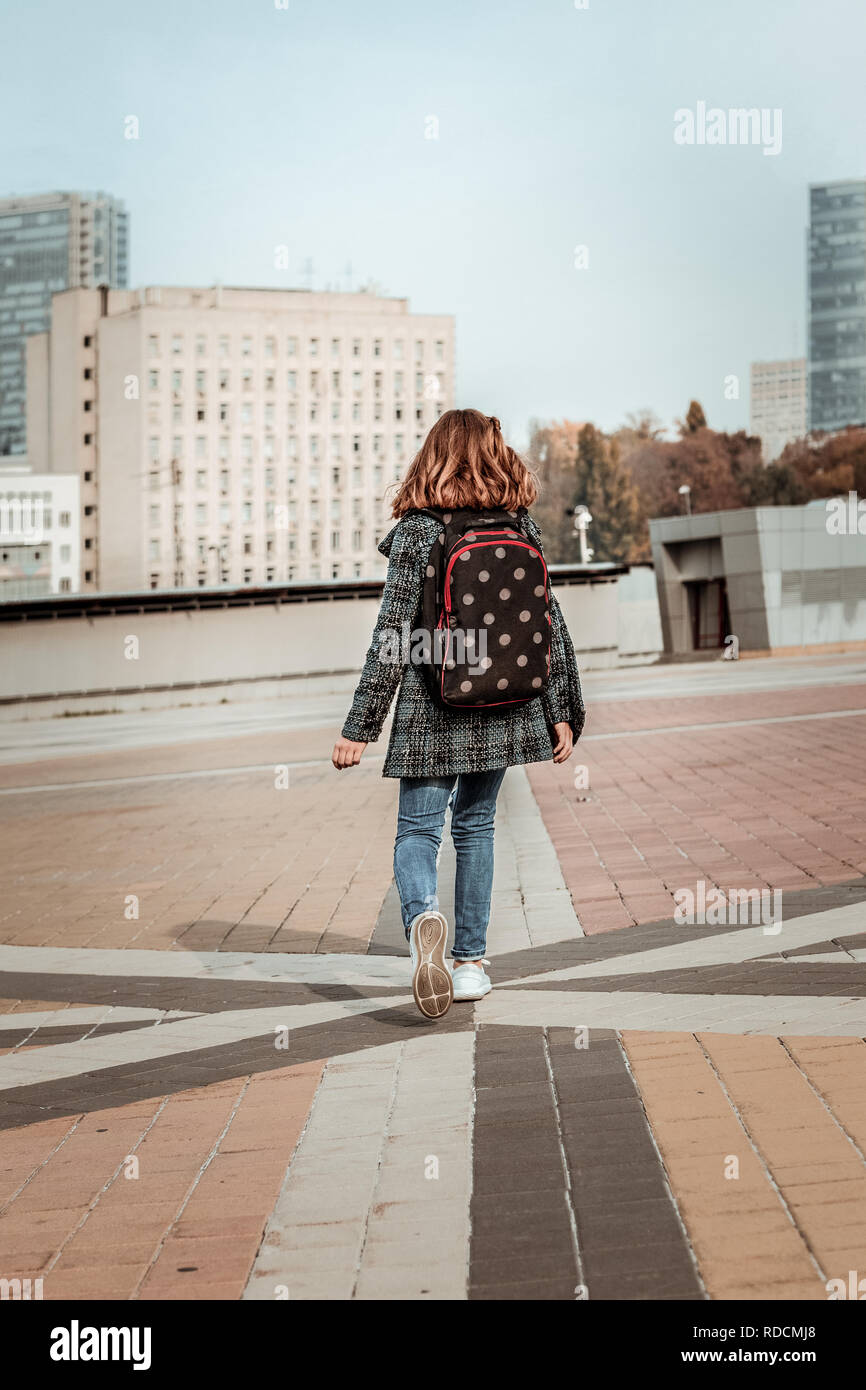 Kid walking alone at the city center Stock Photo - Alamy
