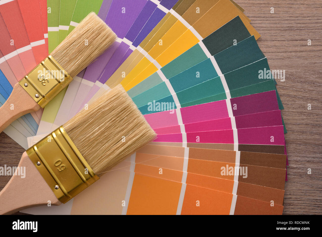 brushes on color fan chart on a brown wooden table. Horizontal ...