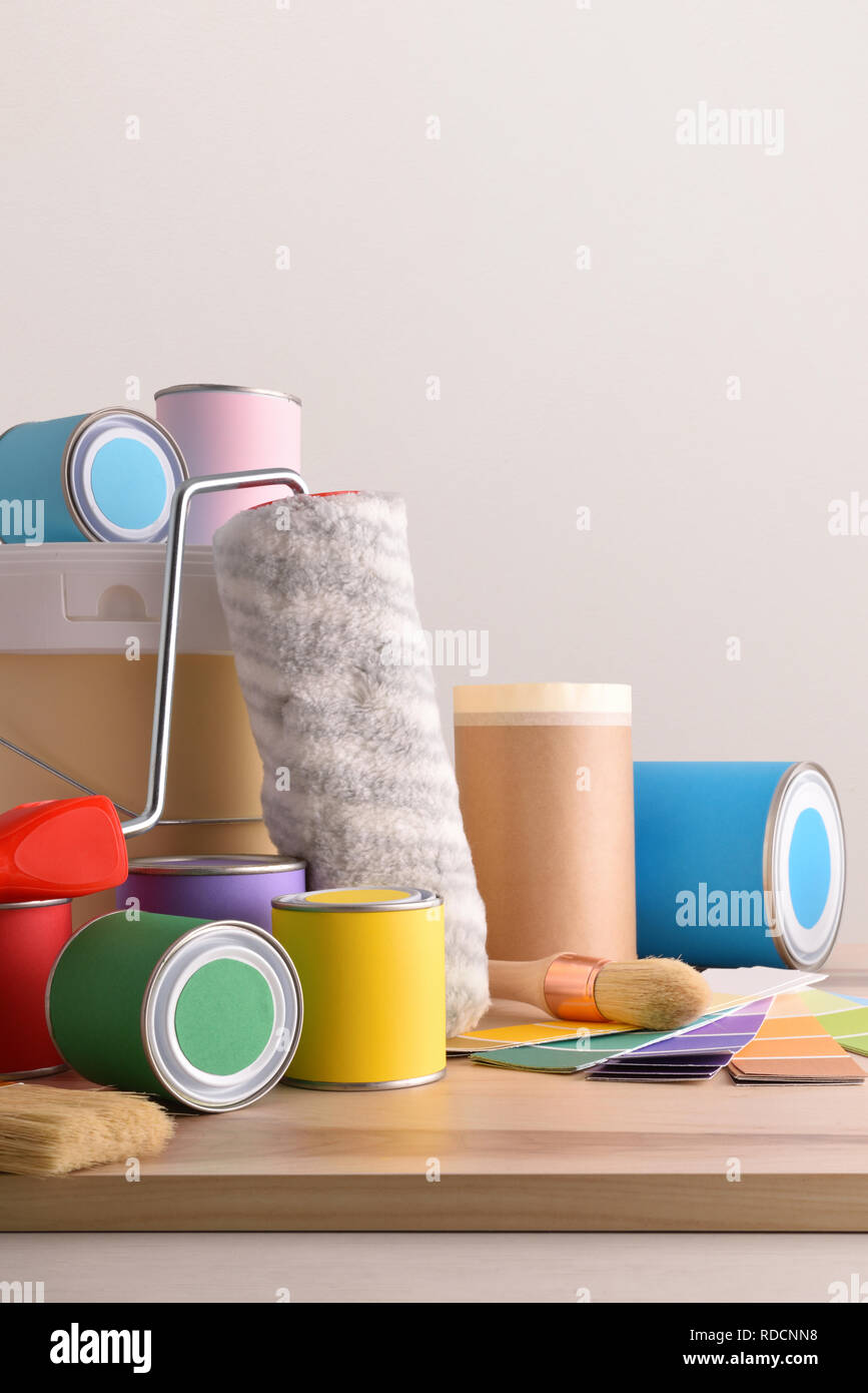 Wooden table with material and painting tools for home and white wall ...