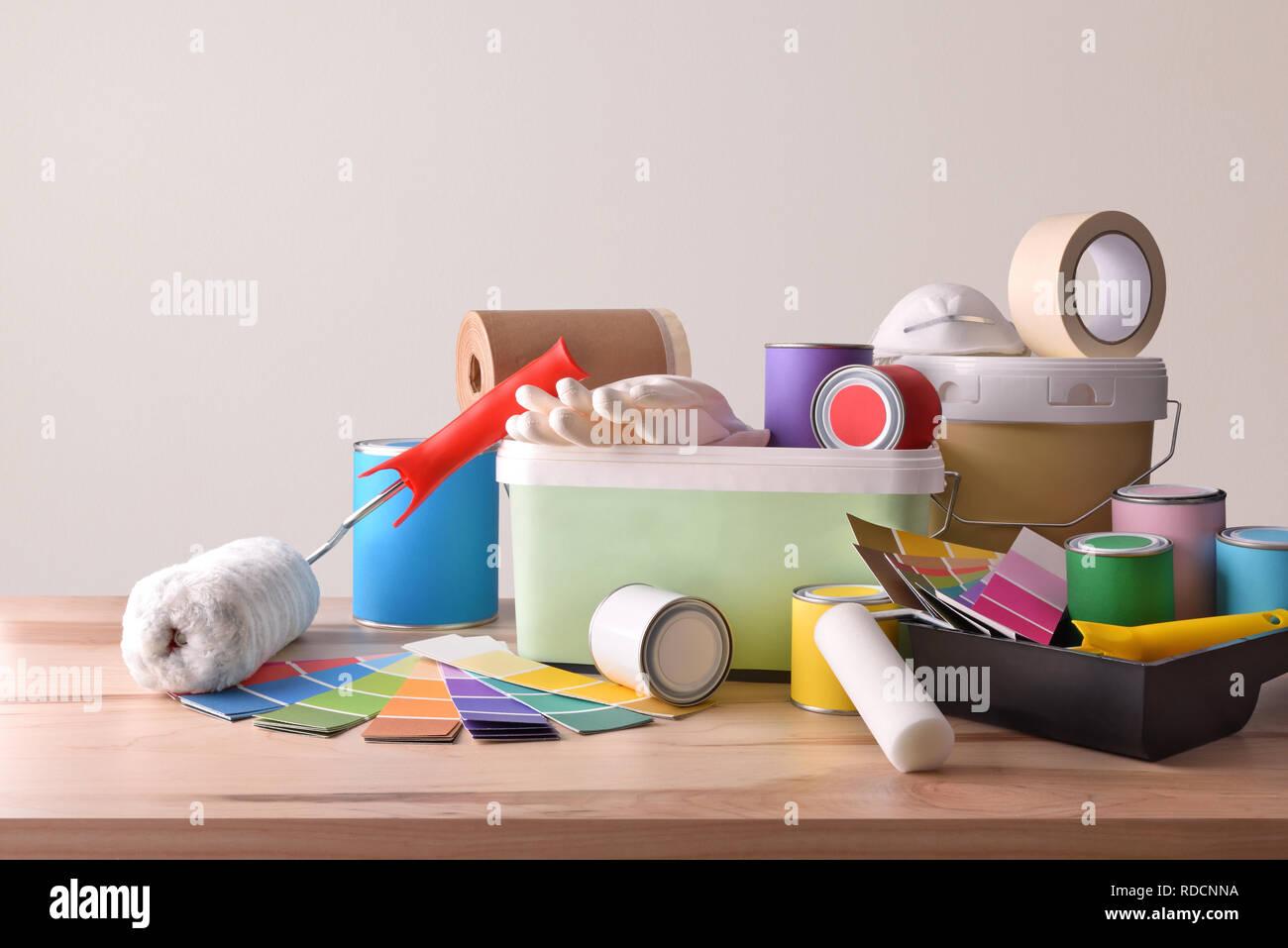 Wooden table with material and painting tools for home and white wall ...