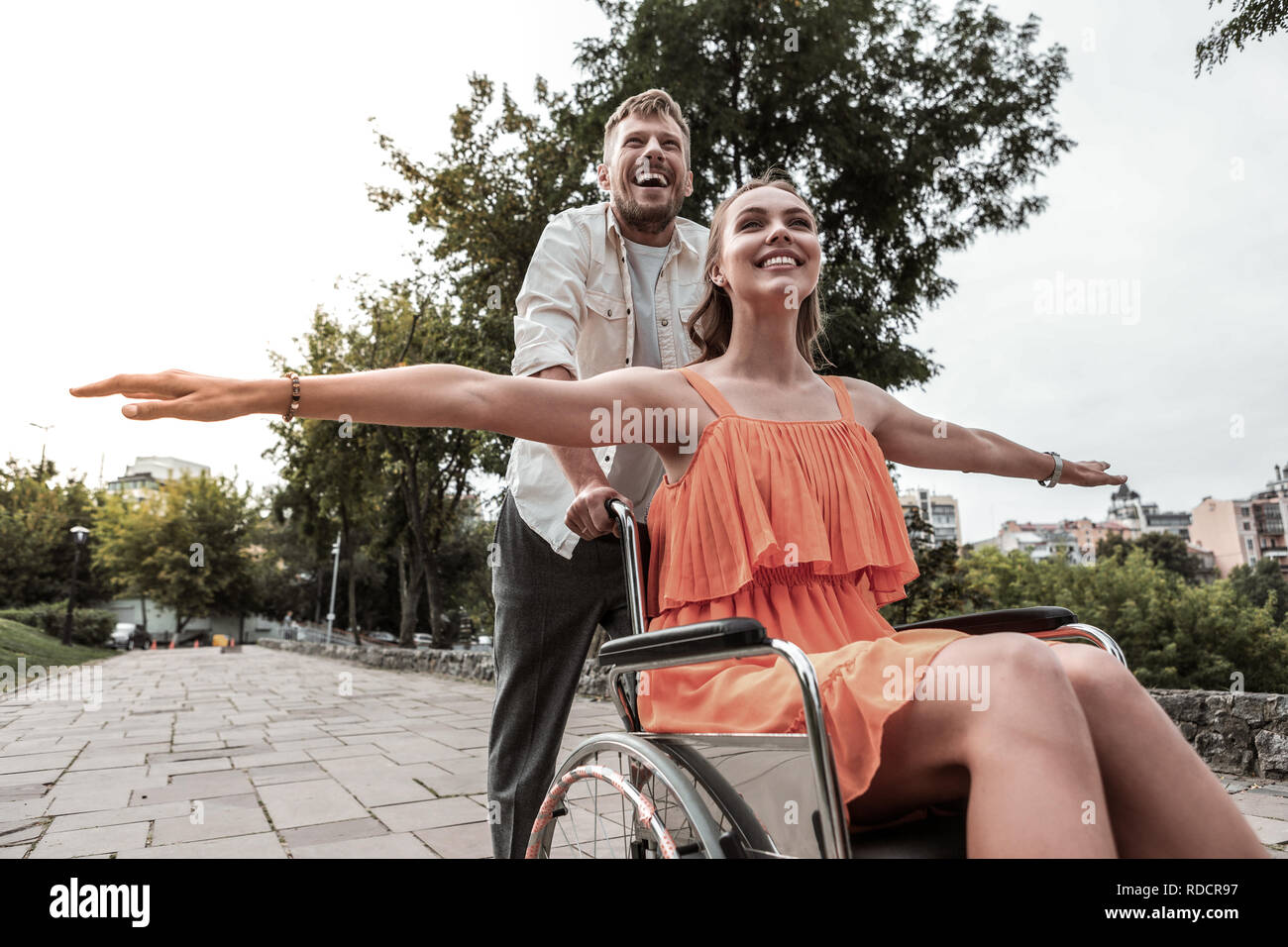Handsome young man helping pretty disabled girl Stock Photo - Alamy