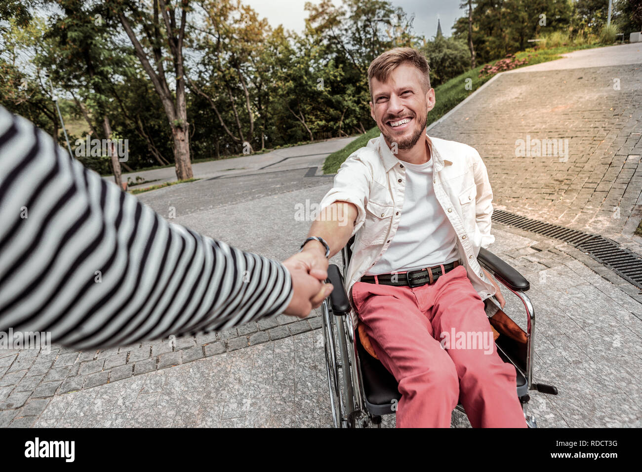 Joyful disabled male person following his friend Stock Photo - Alamy