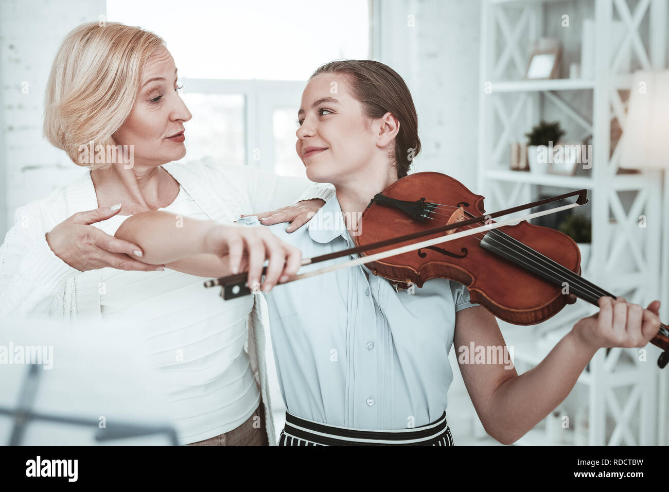Pretty smart girl looking at her grandmother Stock Photo - Alamy