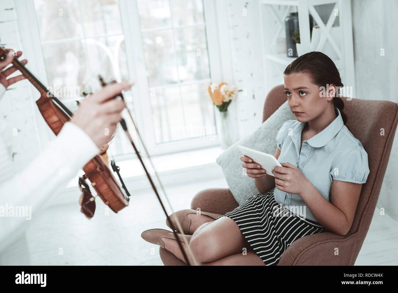 Nice cheerless girl playing on her smartphone Stock Photo - Alamy