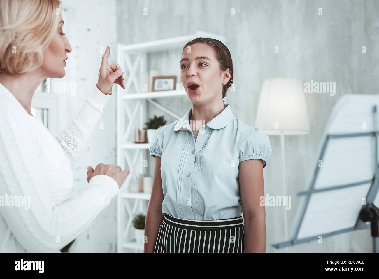 Delighted happy girl raising the tone of her voice Stock Photo - Alamy