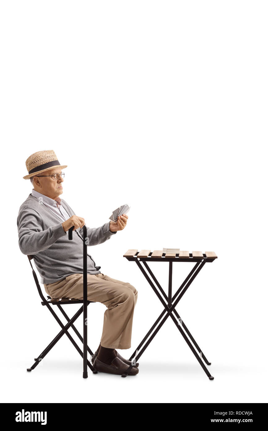 Full length shot of an elderly man playing cards by himself isolated on ...