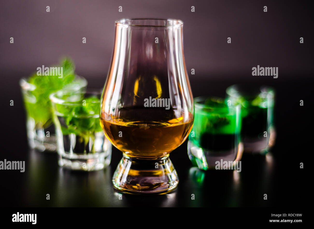 single malt whiskey in a glass and green mint liqueur, refreshing set ...