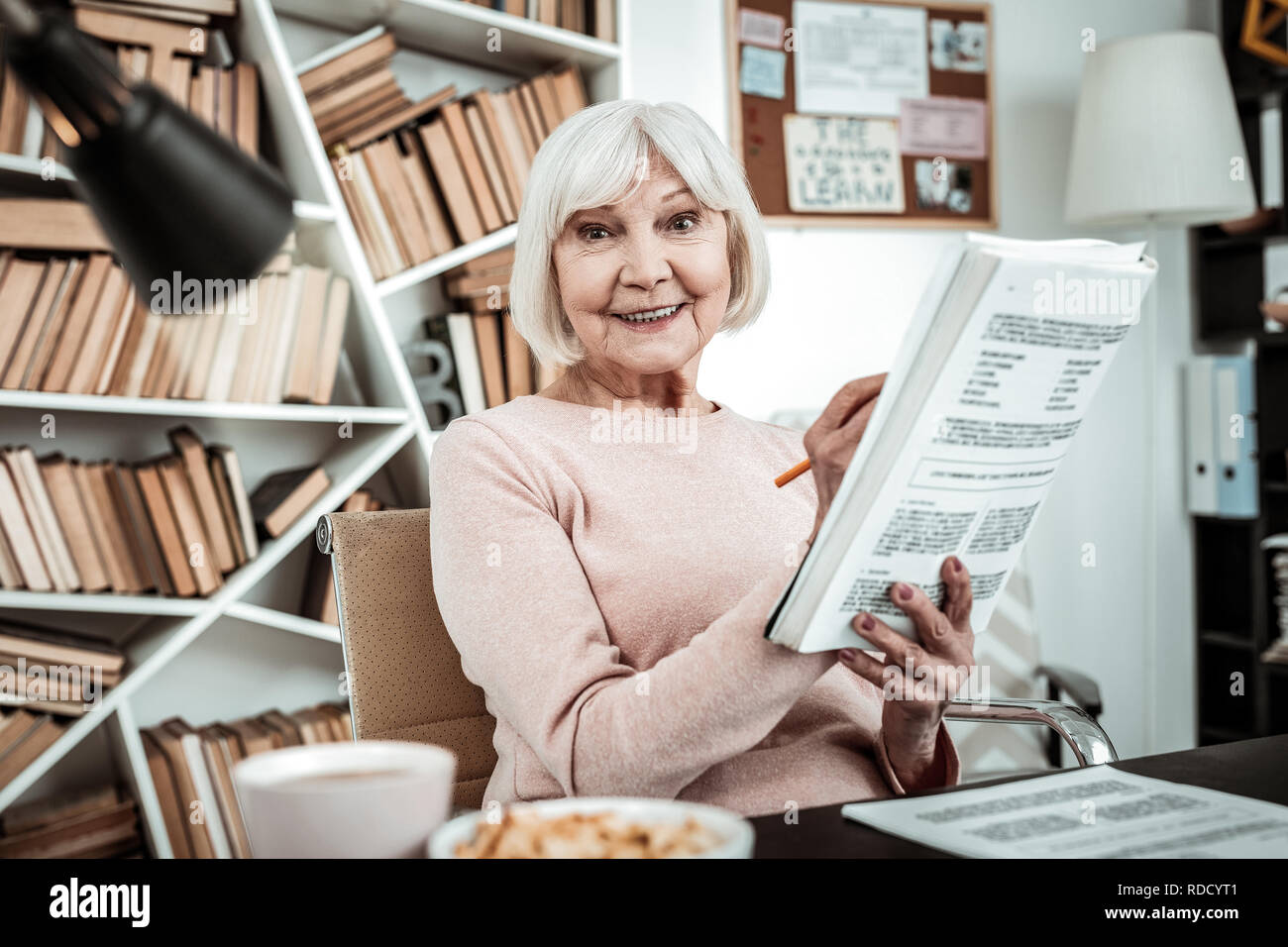 Cheerful retirement completing task for her classes Stock Photo - Alamy