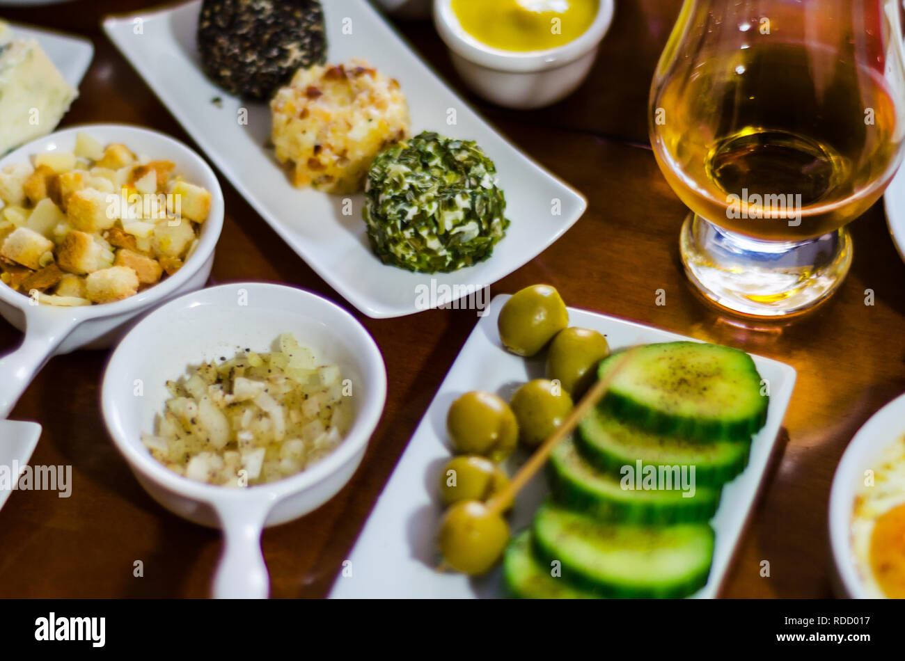 glass of whisky single malt and set with different appetizers in small ...