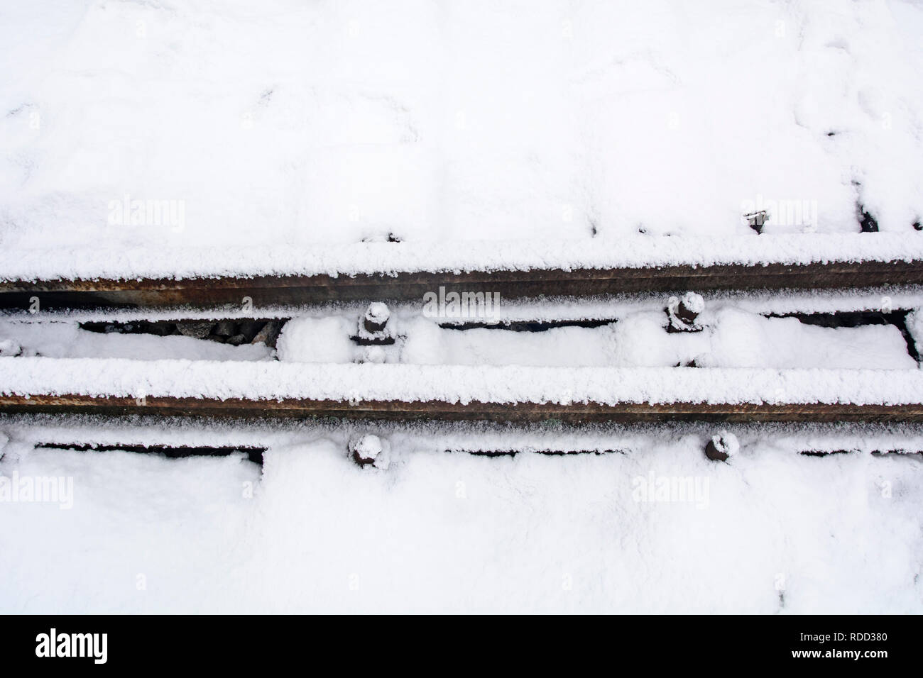 Railroad tracks and crossings at the train station covered by snow ...