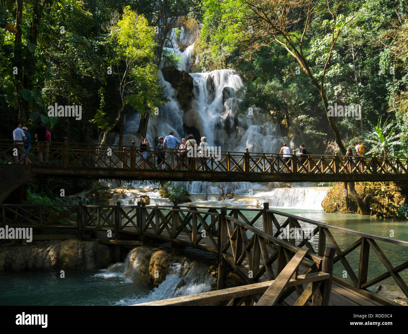 Tourists on bridge viewing upper tier of three tiered Tat Kuang Si ...