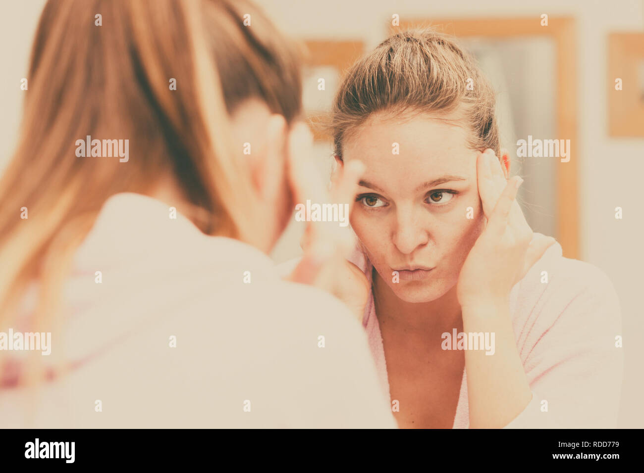 Woman cleaning peeling her face in bathroom, making facial massage with ...