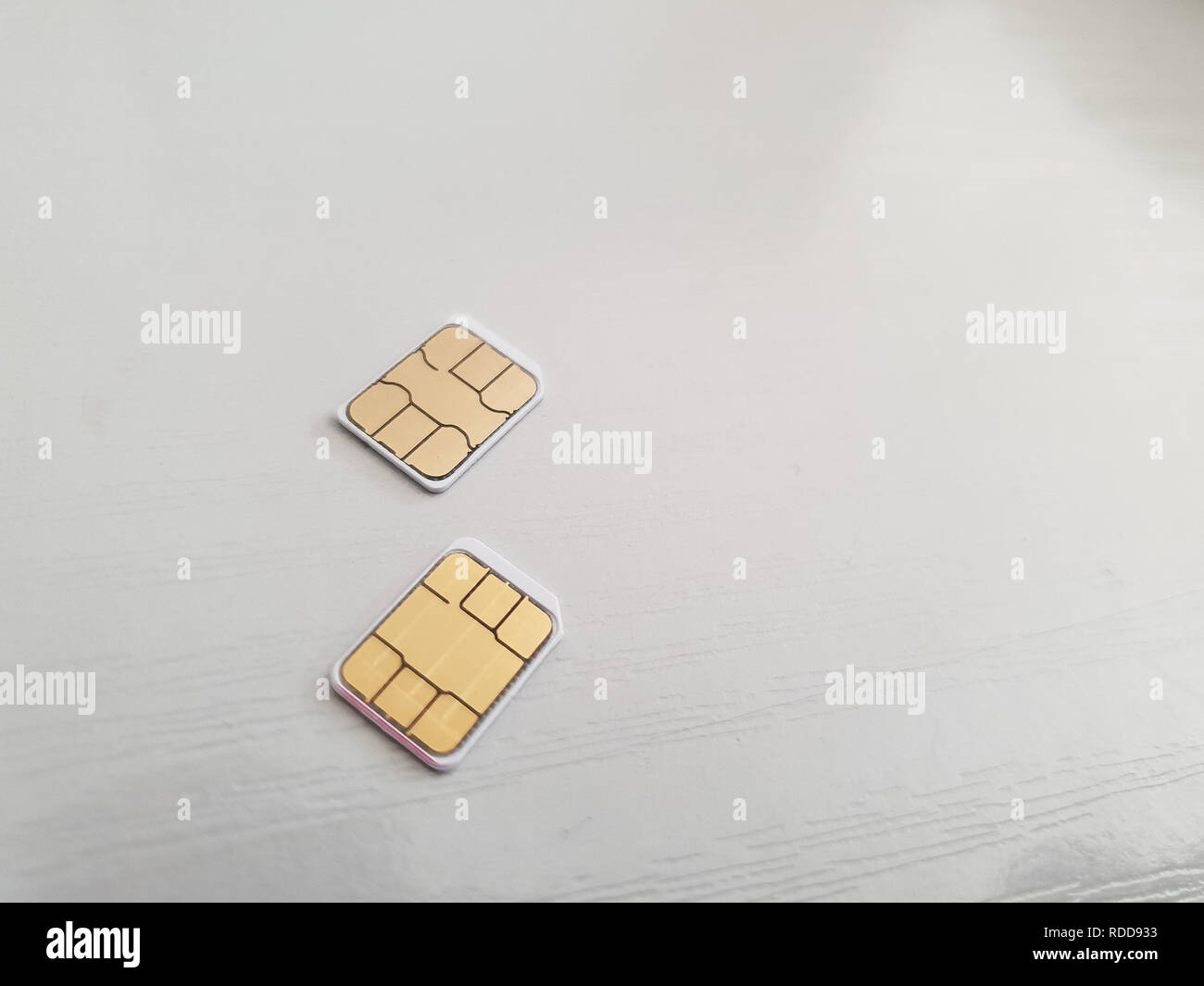 two micro sim cards on a light background surface Stock Photo - Alamy