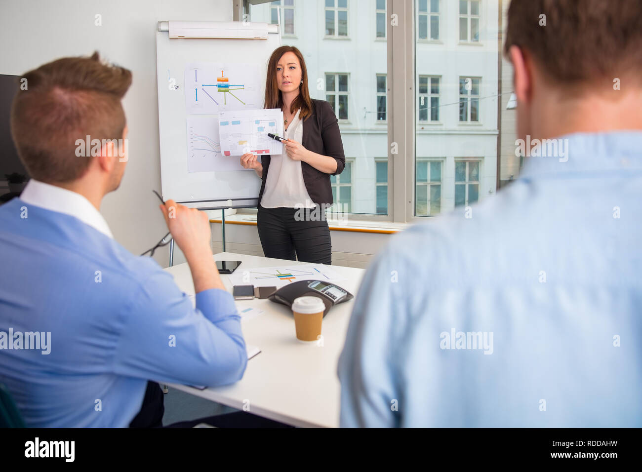 Businesswoman Explaining Chart To Colleagues In Office Stock Photo - Alamy