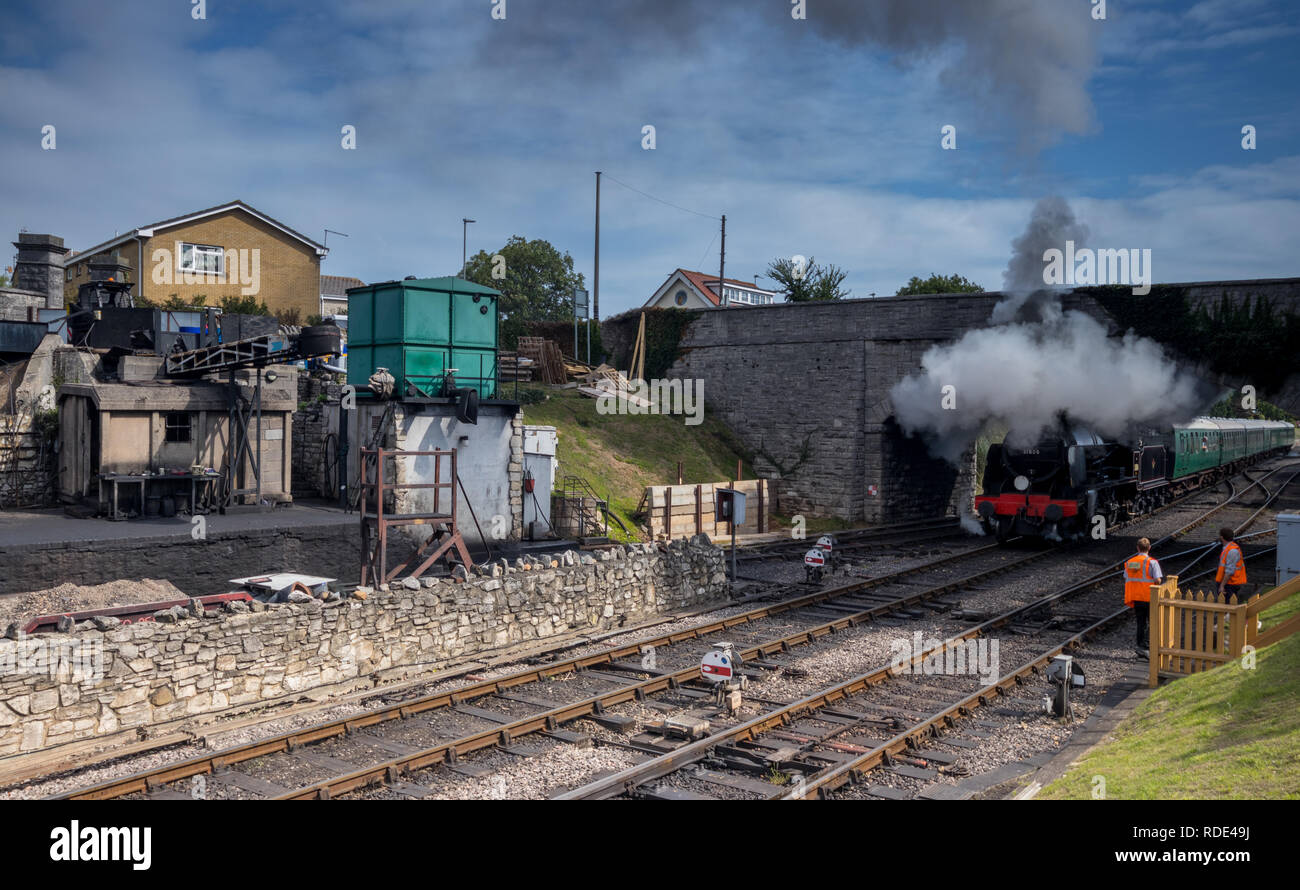 Steam locomotive passing under a bridge near the train station, Swanage ...