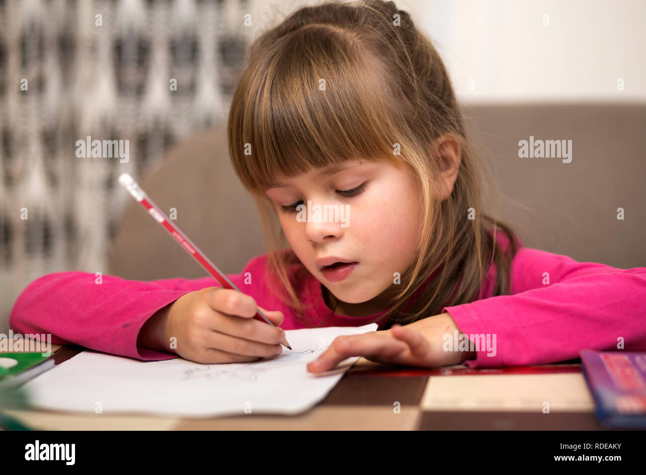 Portrait of cute pretty little serious child girl drawing with pencil ...