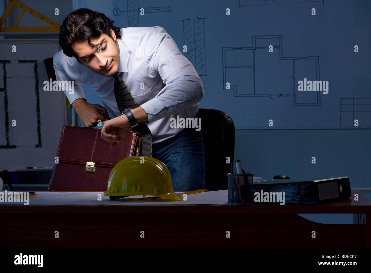 Young construction architect working on project at night Stock Photo ...