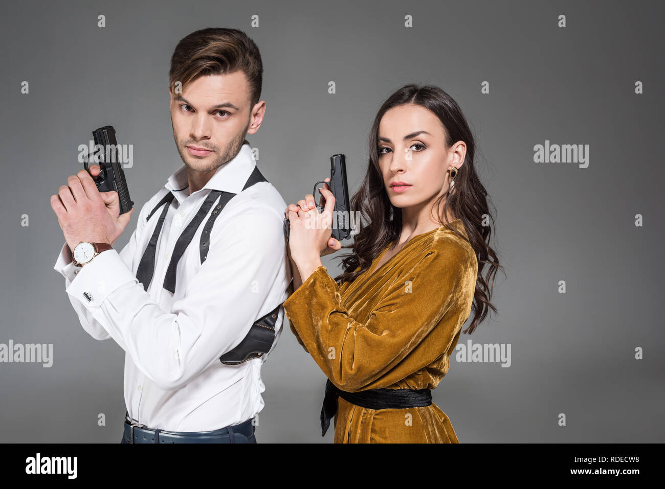 beautiful confident couple of secret agents posing with weapon ...