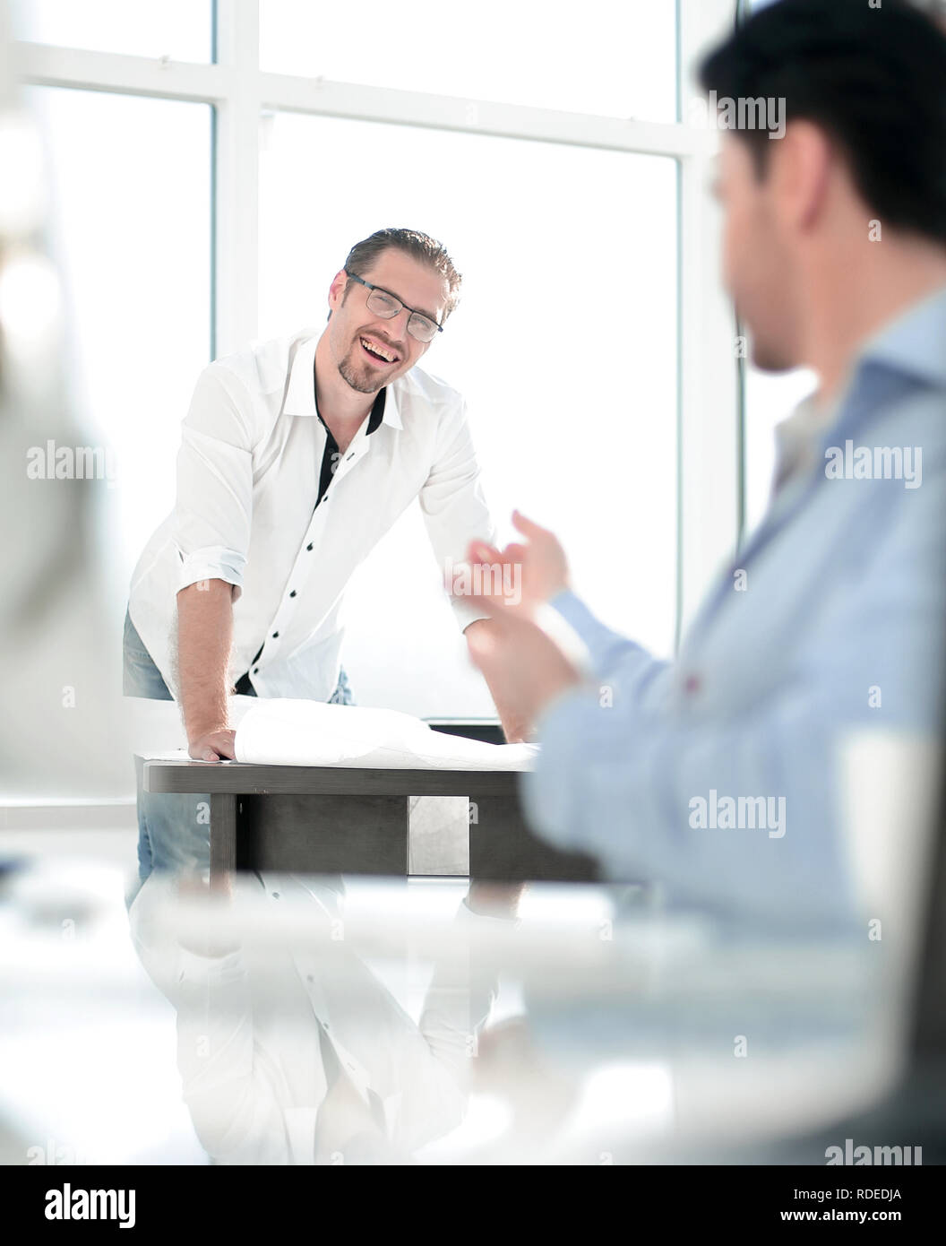 smiling colleagues talking in the workplace Stock Photo - Alamy