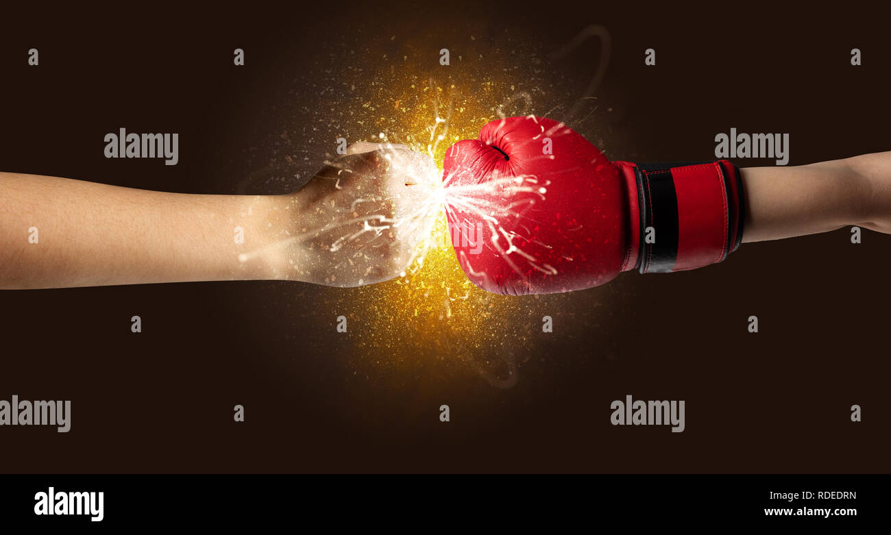 Two hands fighting with orange dust, spark, glow and smoke concept ...