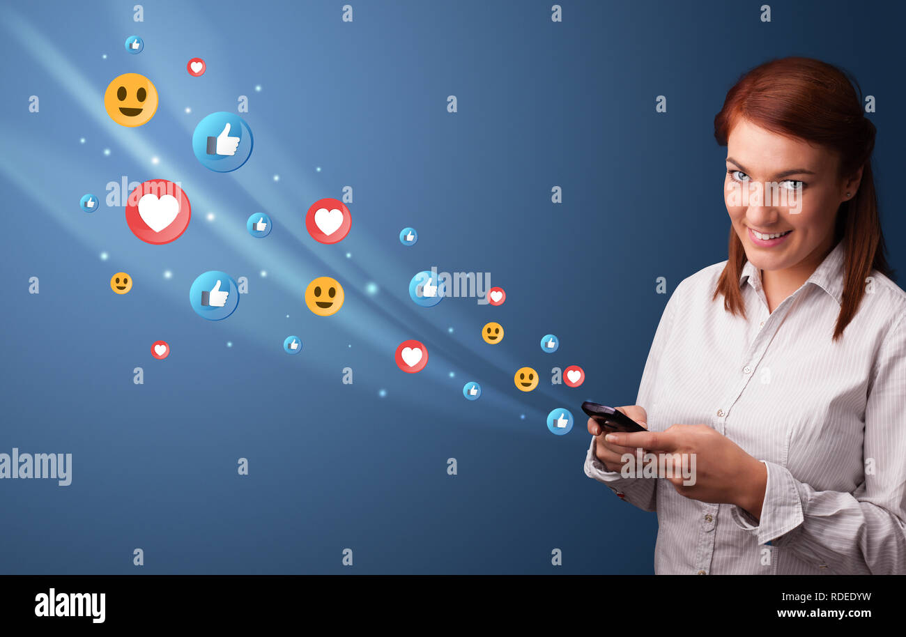 Young person using smartphone with flying social media icons around ...
